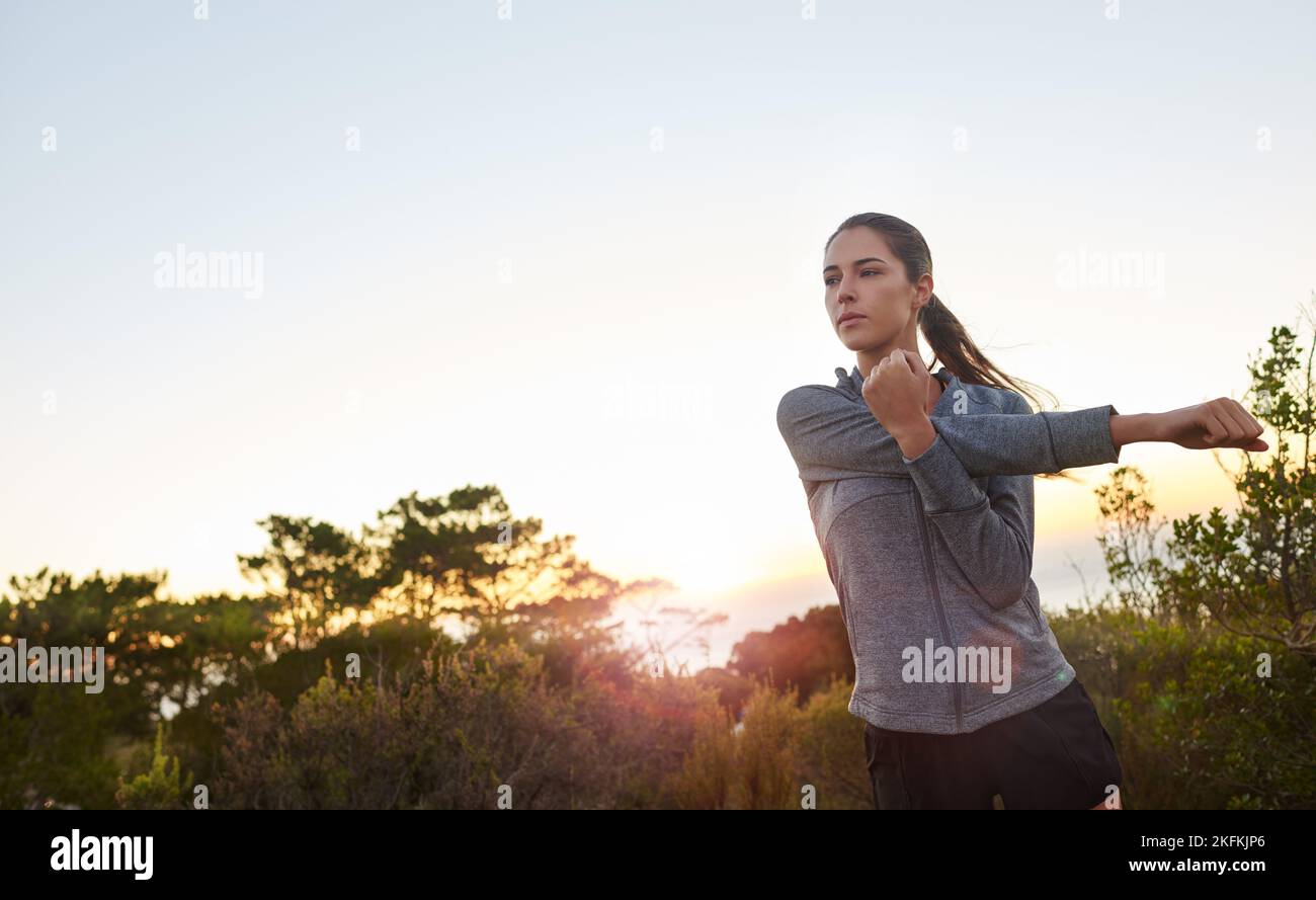 Keeping it balanced. a young woman warming up before her run Stock ...