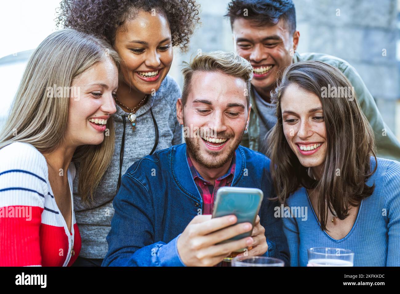 group of multiracial friends having fun using social network, tech ...