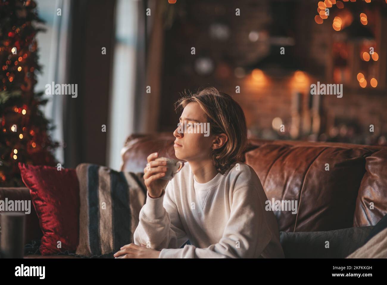 Young teen boy with long hair thoughtful look sad eyes negative mood ...
