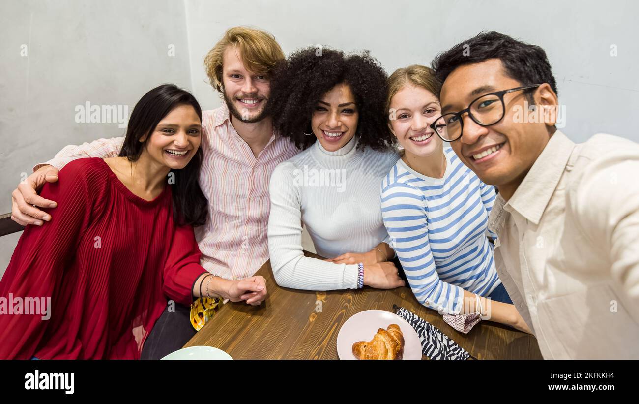 smiling friends taking a selfie during breakfast, multiracial ...