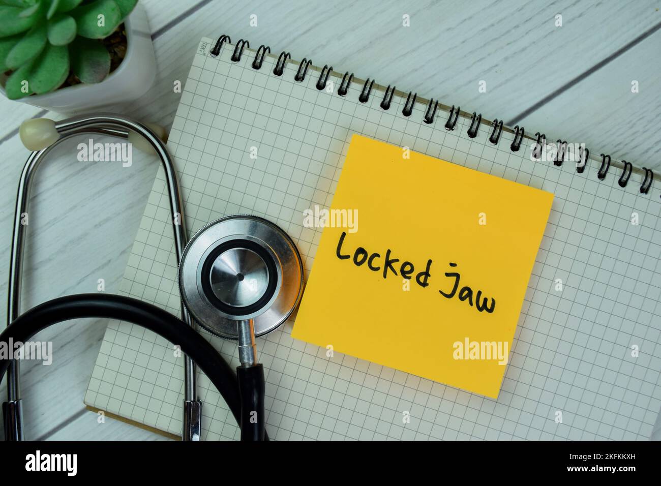 Concept of Locked Jaw write on sticky notes isolated on Wooden Table ...