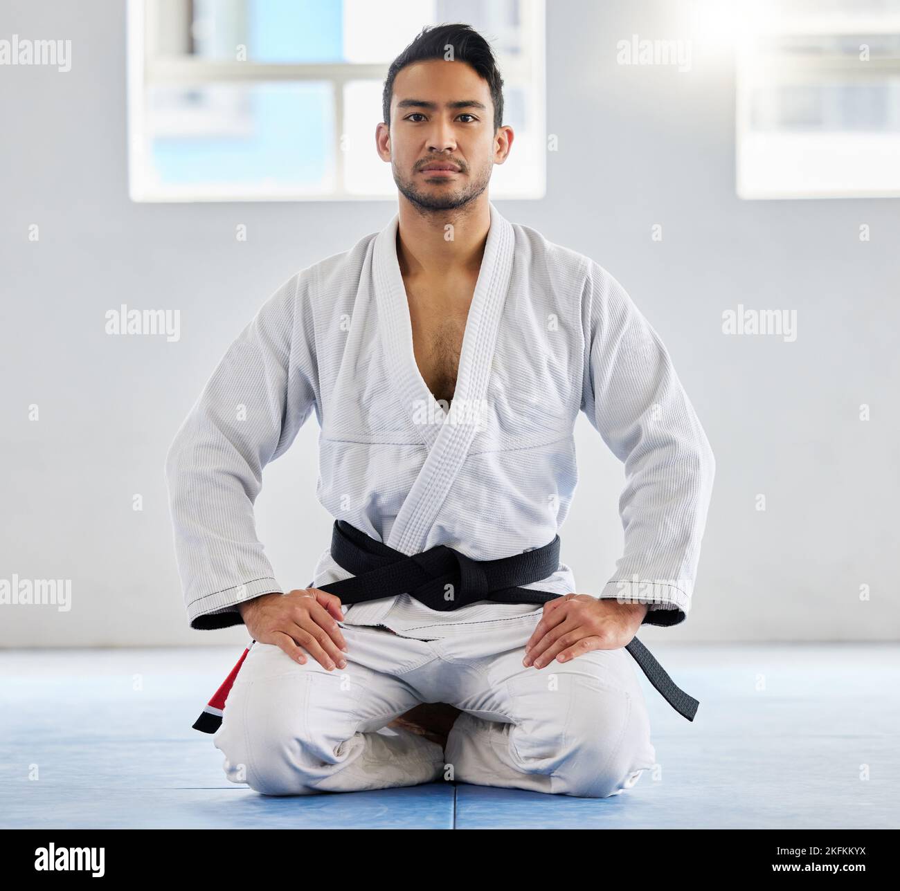 Portrait, karate and sensei with a sports man kneeling on the gym floor ...