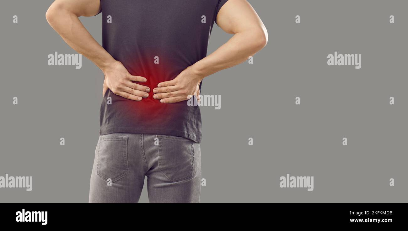 Young man who suffers from backache is holding hands on his painful ...