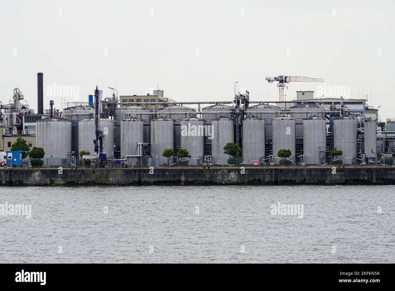 Storage tanks for oil and gasoline at the edge of a harbor basin on a ...
