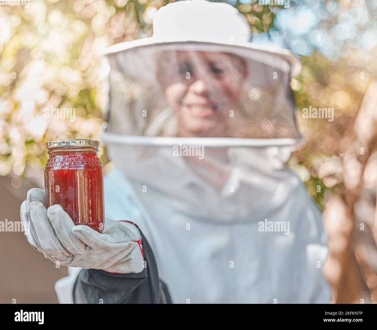 Hand, honey and jar with a woman beekeeper working in the countryside ...