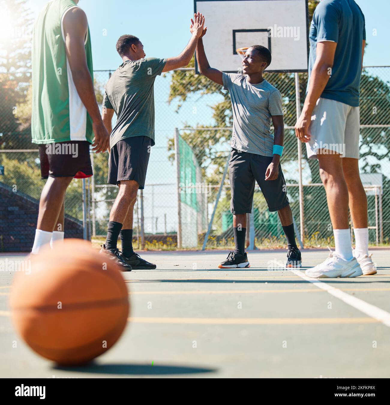 Teamwork, high five and sports with friends on basketball court for ...