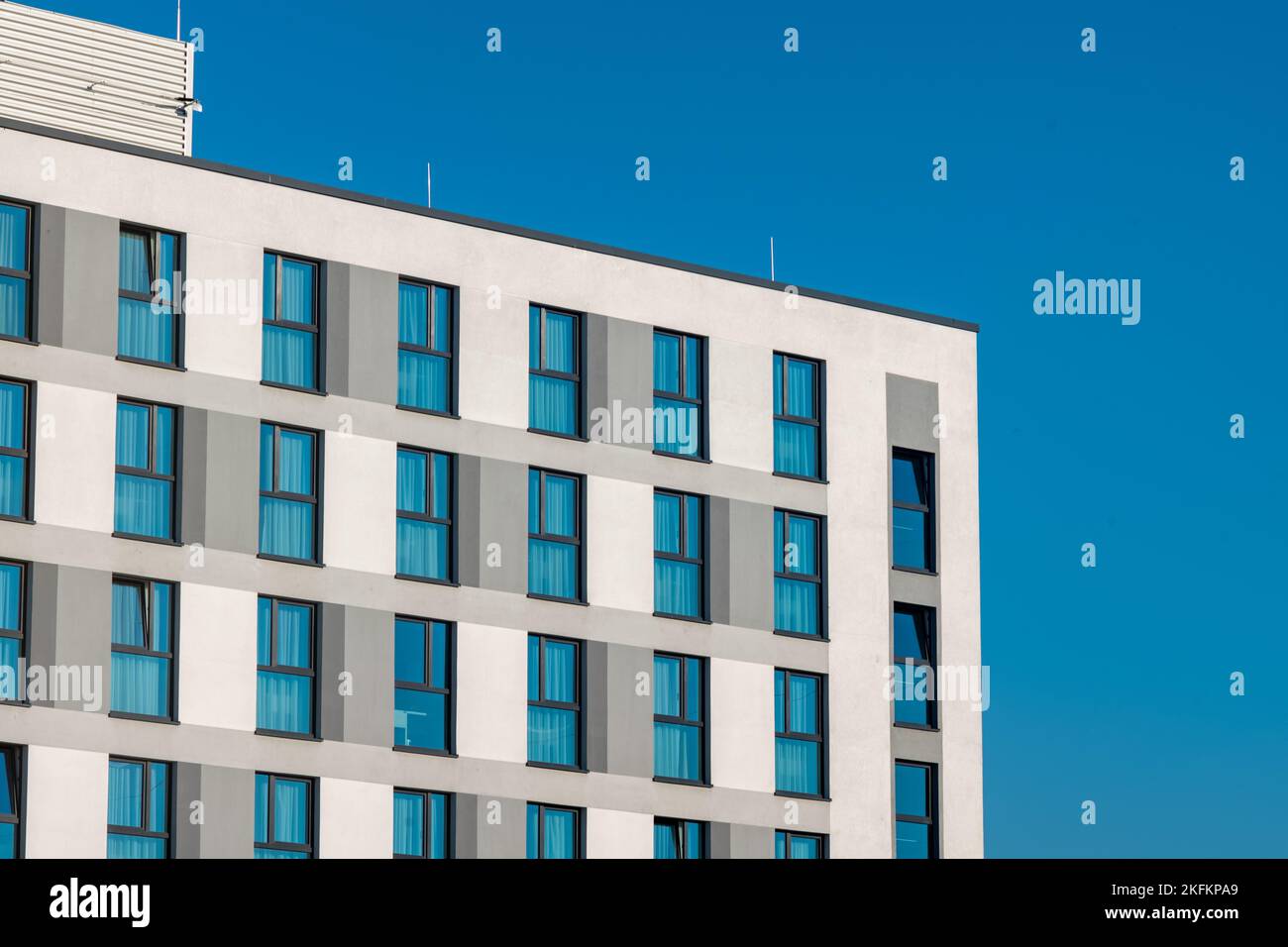 An exterior view of a modern building with white walls and glass ...
