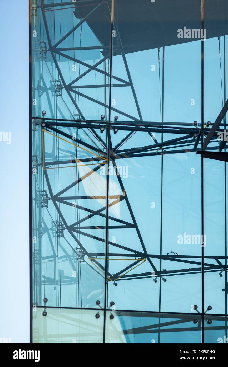 A vertical shot of a building with blue glass windows in clear sky ...