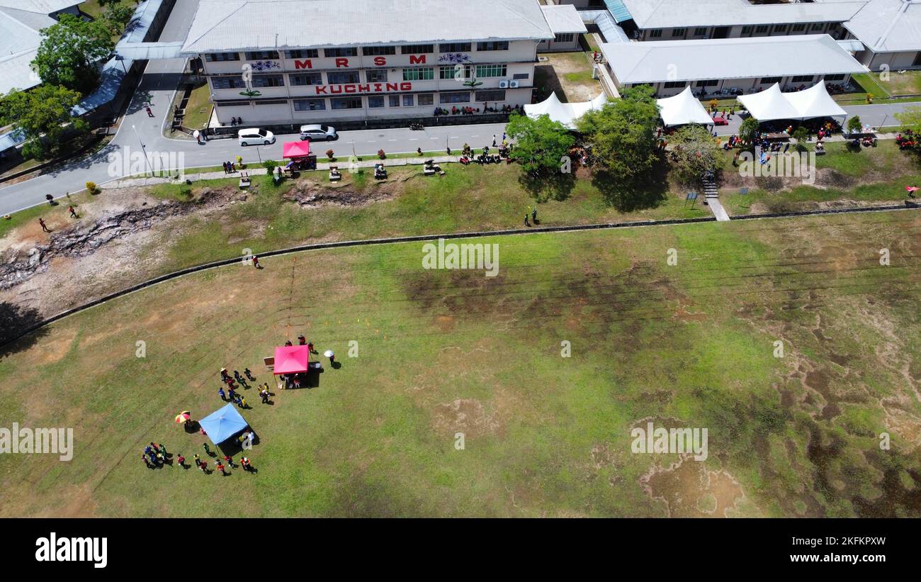 An aerial of a field of MRSM Kuching Sarawak with trees and people ...