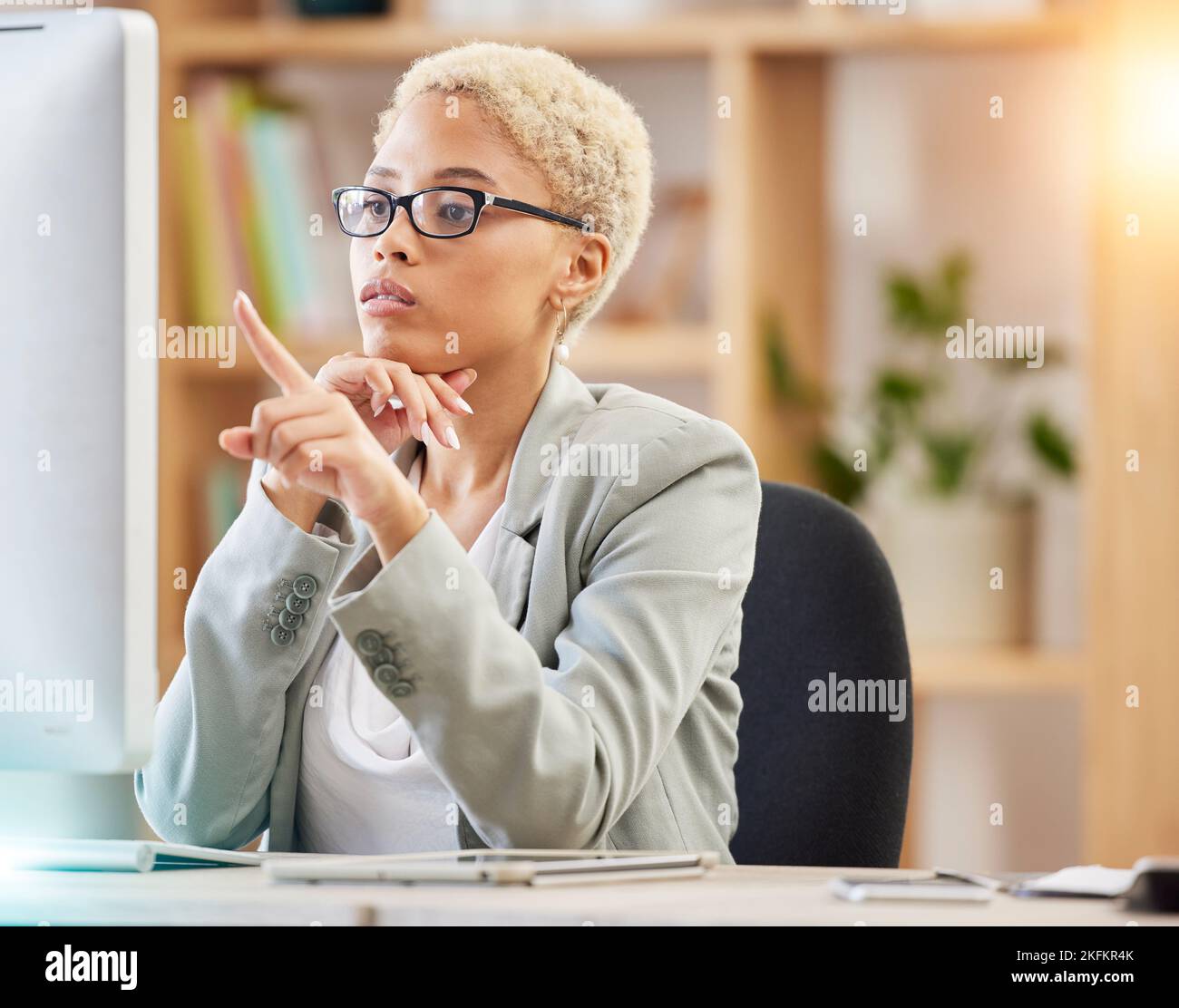Black woman, computer and office desk while pointing at screen for ...