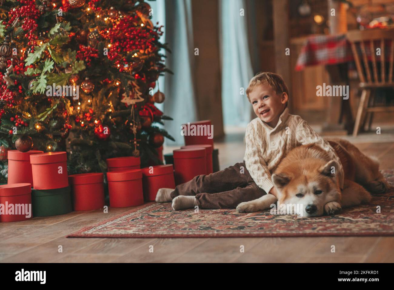 Smiling small child having fun with dog waiting for miracle Santa at ...