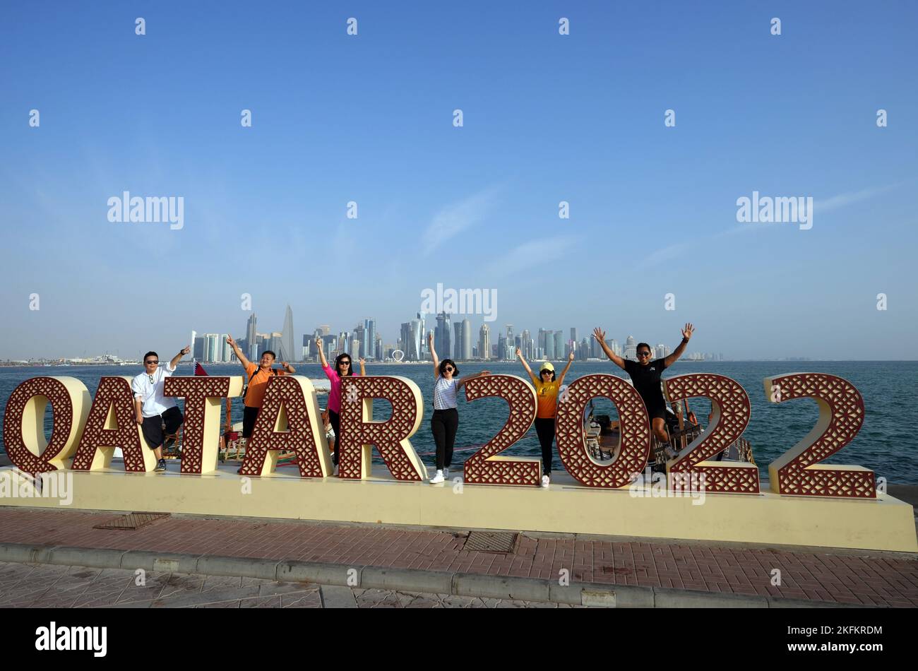 People pose for a picture at the Qatar 2022 sign, Doha Corniche, ahead ...
