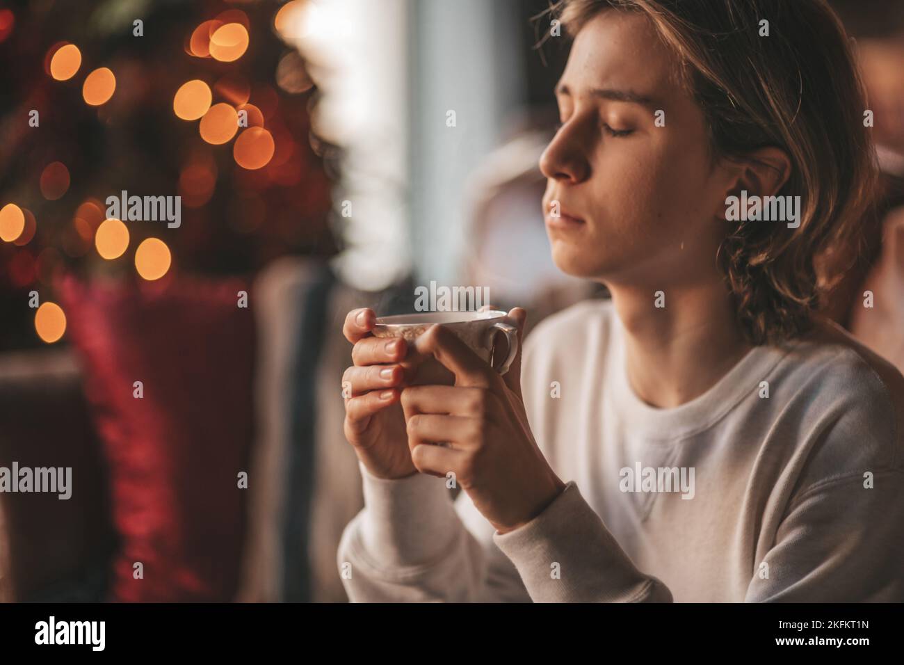 Young teen boy with long hair thoughtful look sad eyes negative mood ...