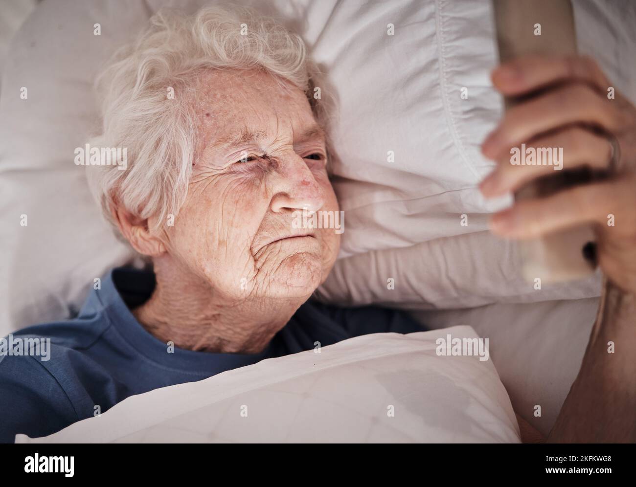 Phone, face and morning with a senior woman waking up in bed in the ...