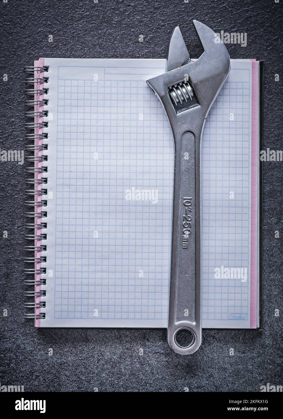 Adjustable wrench notebook on black background construction concept ...