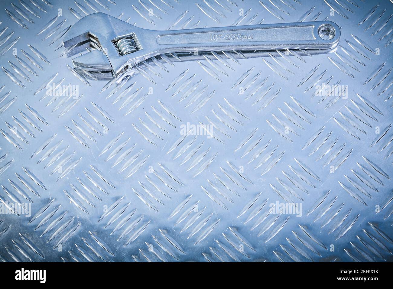 Adjustable spanner on fluted metal background construction concept ...