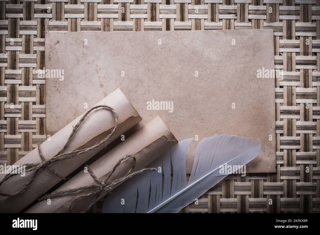 Antique clean sheet paper scroll plume on woven wooden mat Stock Photo ...