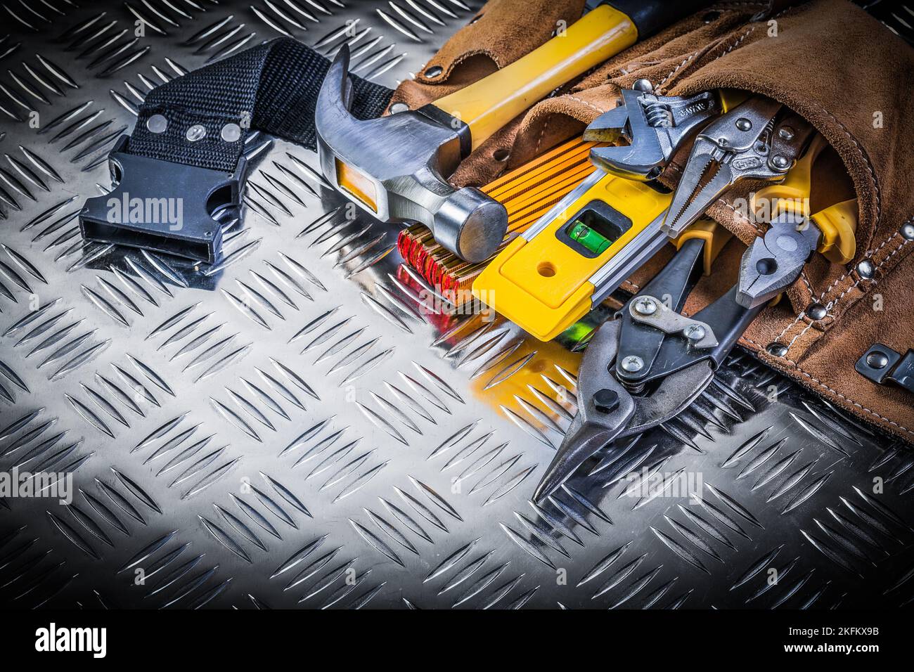 Assortment of construction tooling in leather tool belt on channeled ...