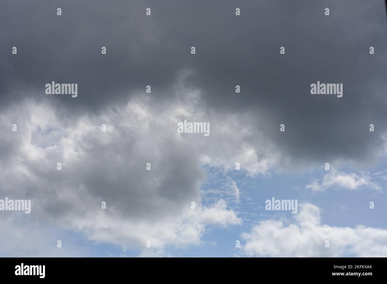 A sky full of clouds, with sections of gray and blue and black, just ...