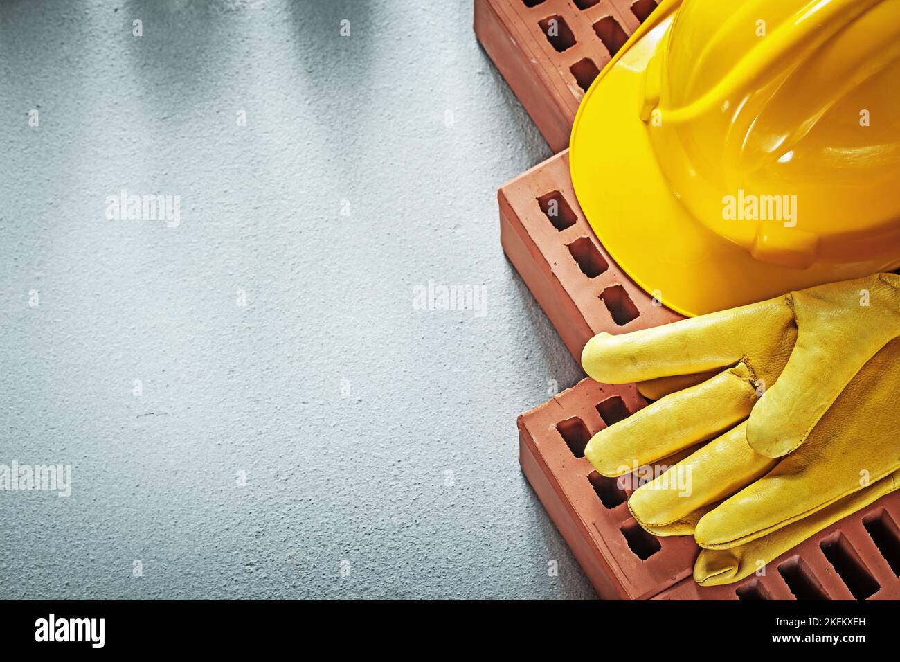 Assortment of red building bricks protective hard hat safety gloves on ...