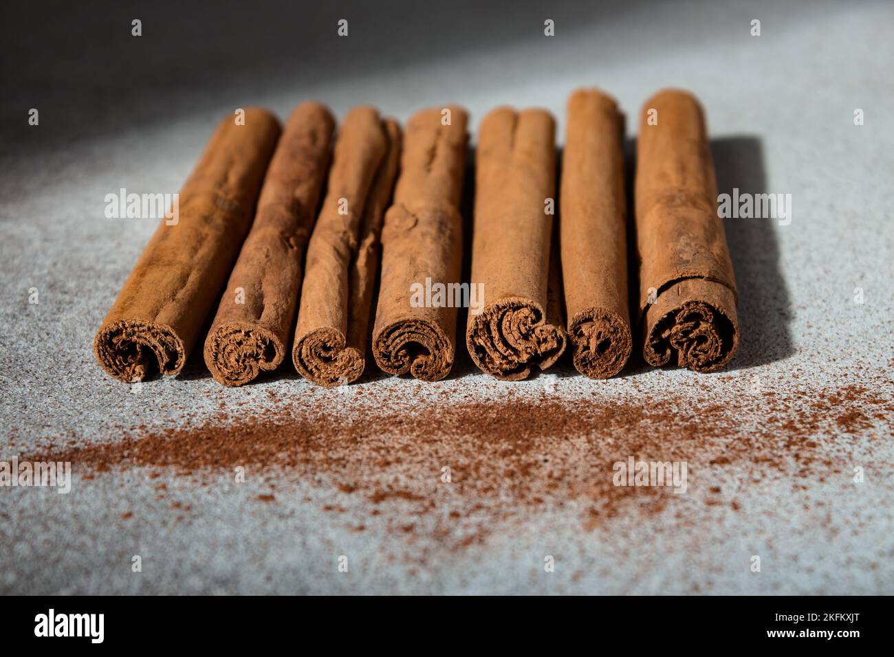 Ground Ceylon cinnamon sprinkled in front of real cinnamon sticks on a ...