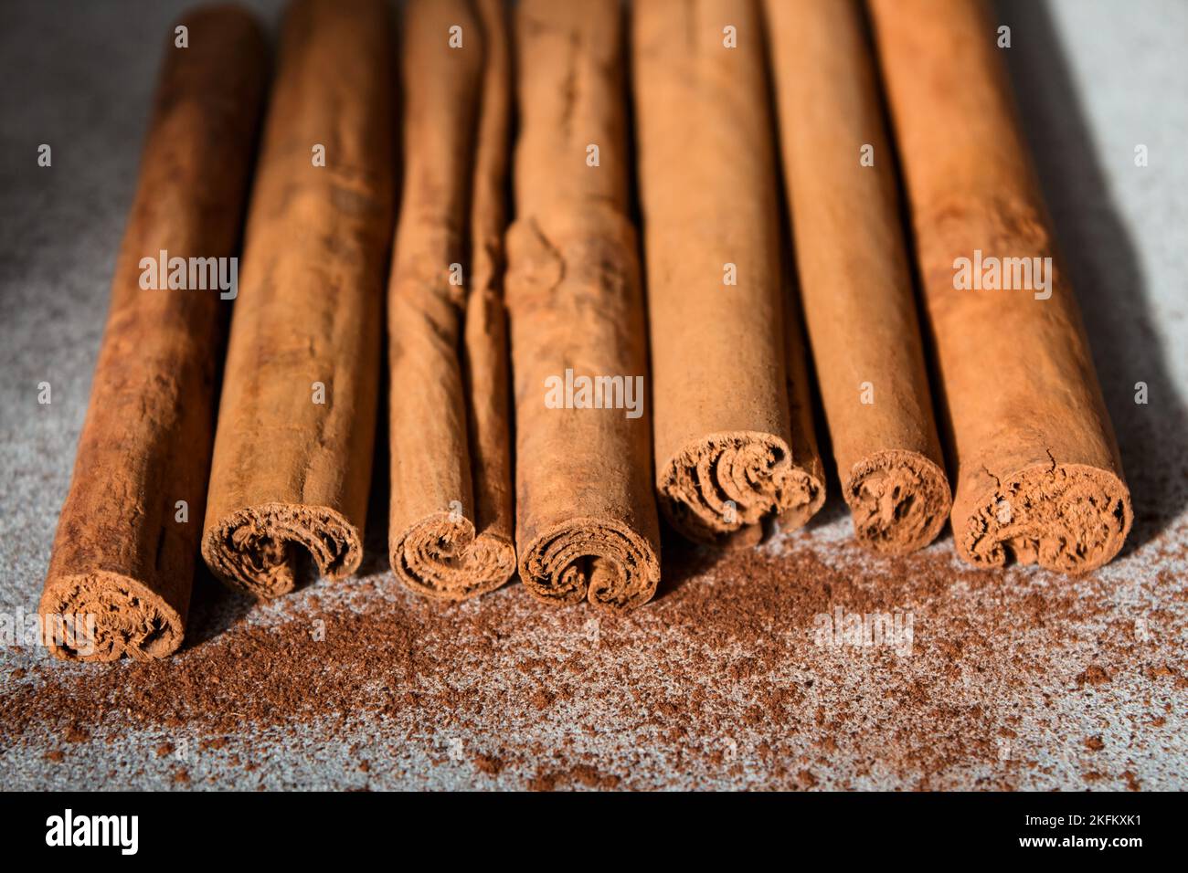 Ground Ceylon cinnamon sprinkled in front of real cinnamon sticks on a ...