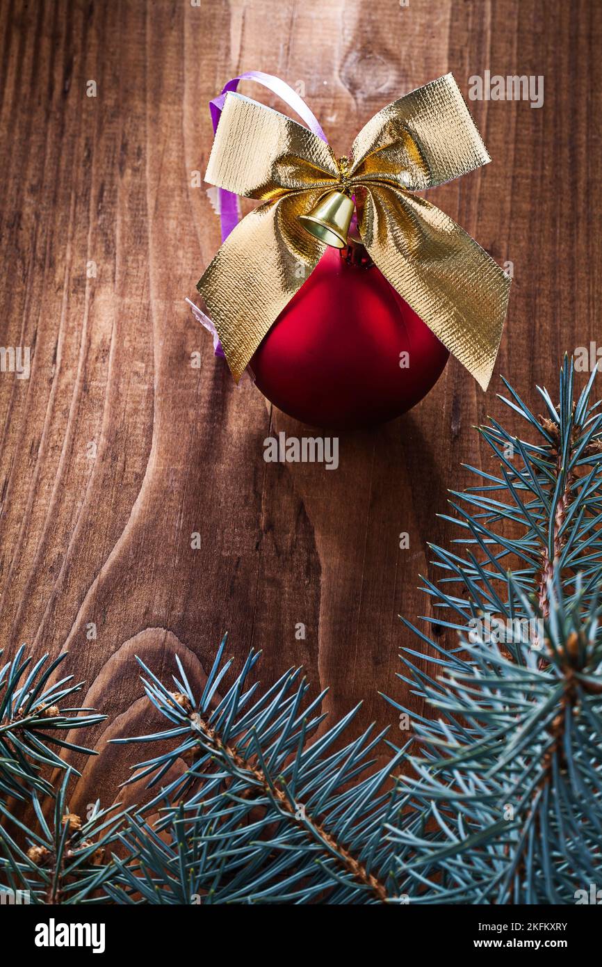 big red christmas ball and gold colored bow with branches of fir tree ...