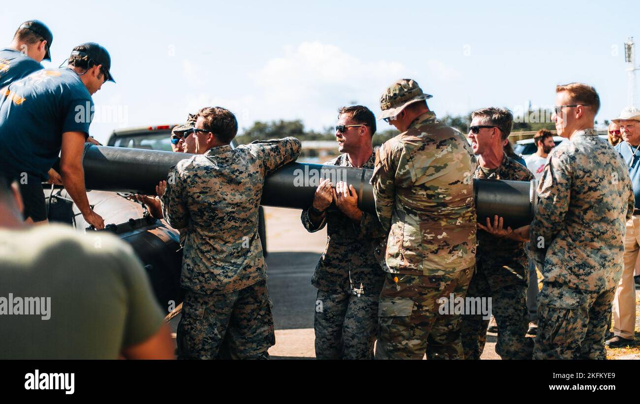 U.S. service members with the Navy, Marine Corps, and Air Force load an ...