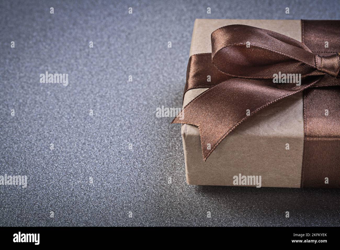 Boxed gift with brown knot on grey background copy space celebrations ...