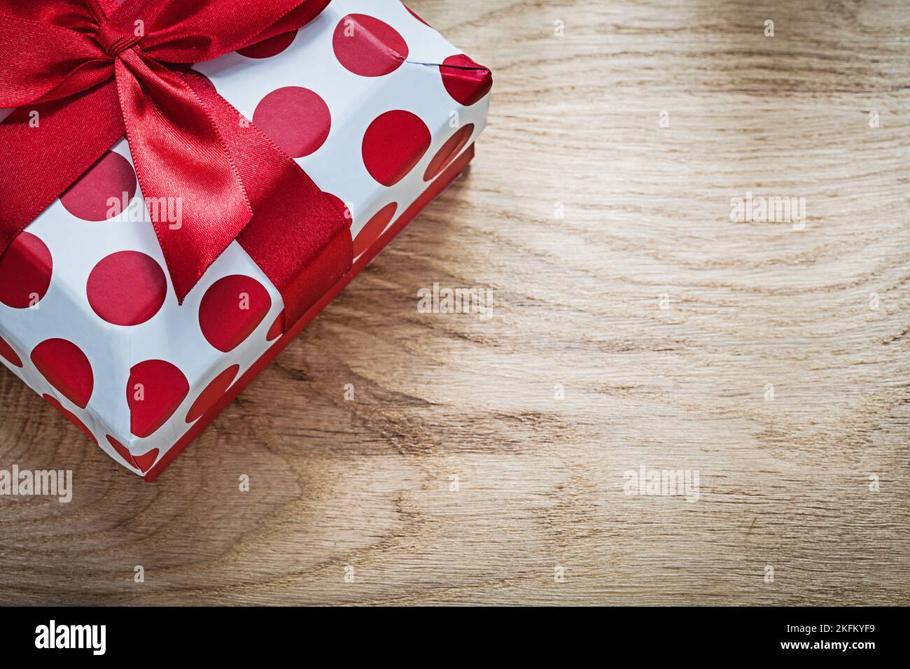Boxed present with red ribbon on wooden board celebrations concept ...