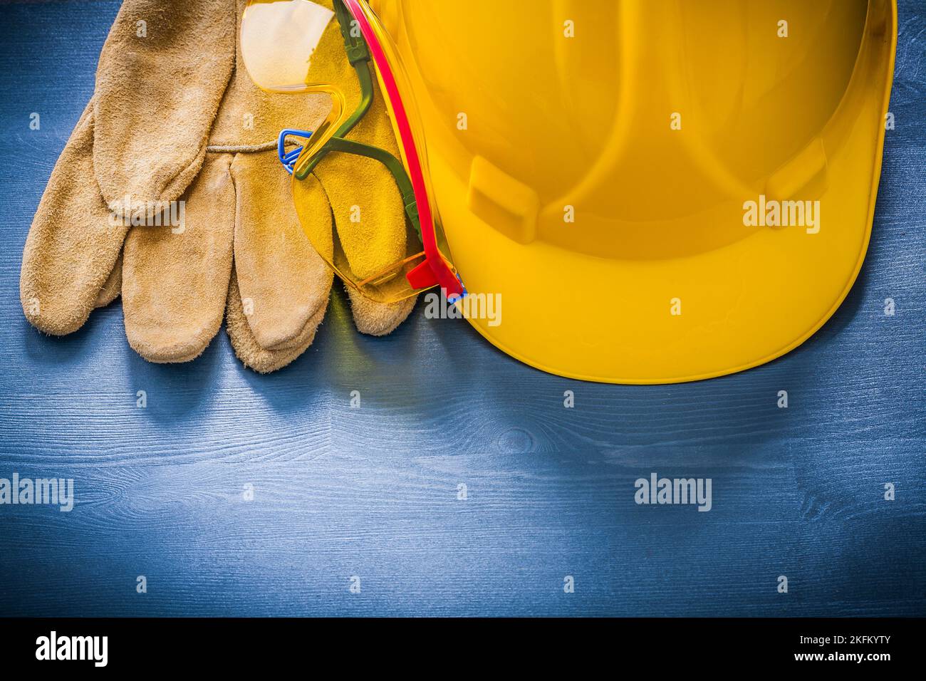 Building helmet goggles safety gloves on wooden board construction ...