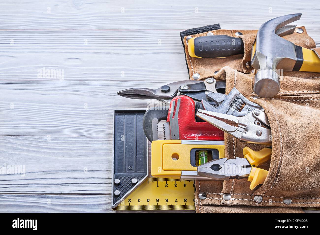 Building implements in leather tool belt on wooden board construction ...