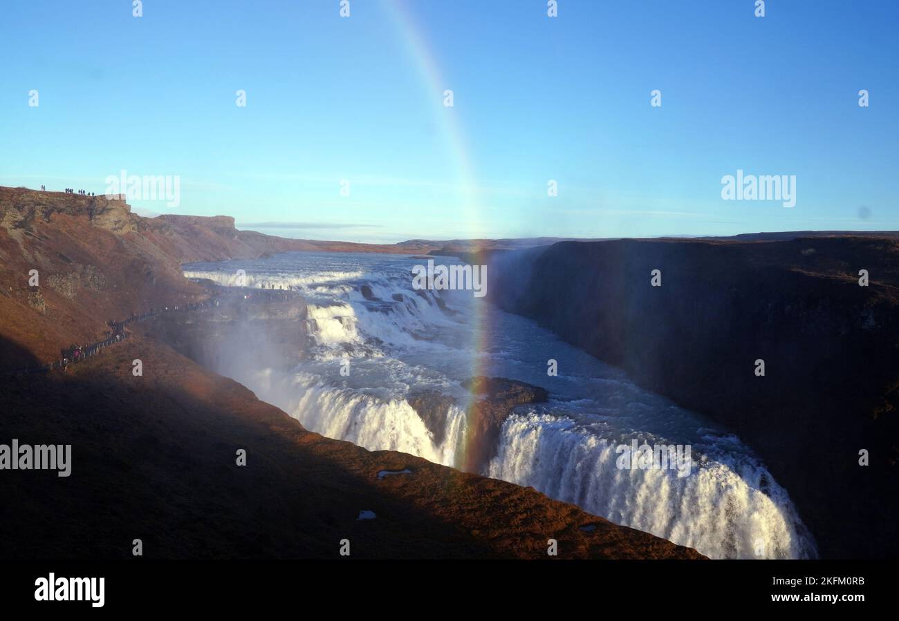 A rainbow appears through the spray at Gullfoss waterfall on the south ...