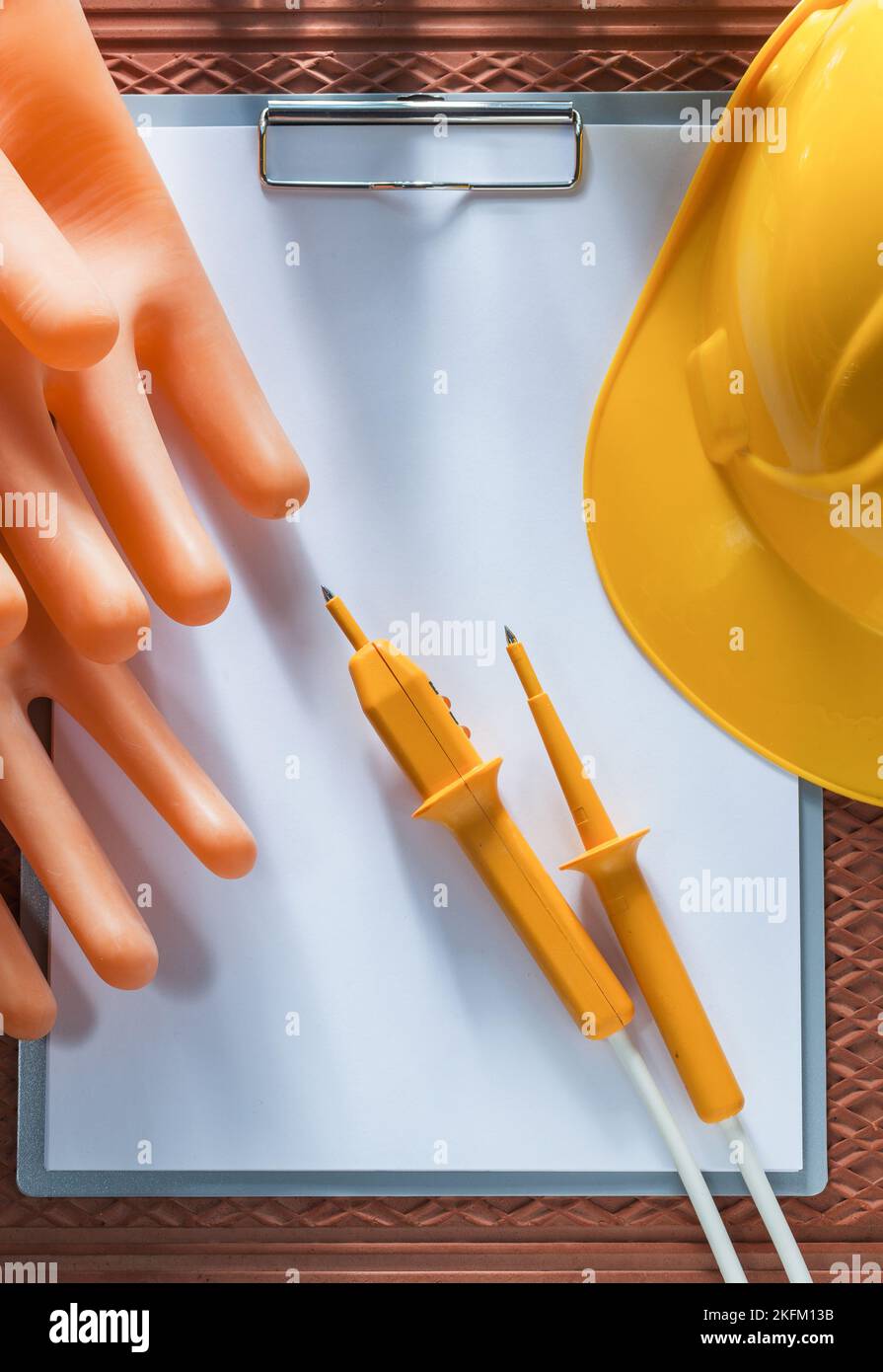 Clipboard paper hard hat insulating gloves electric tester on ...