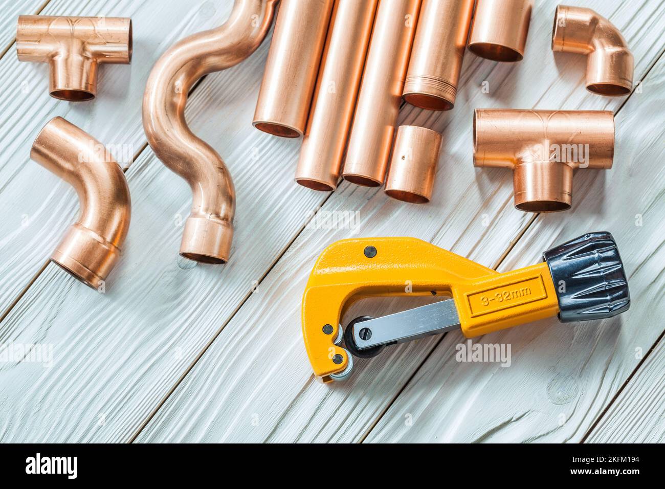 close up view copper pipes and fittings pipecutter on white boards ...