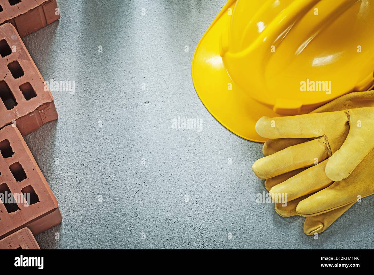 Collection of red bricks building helmet protective gloves on concrete ...