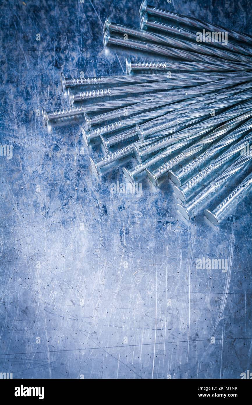 Collection of stainless construction nails on scratched metallic ...