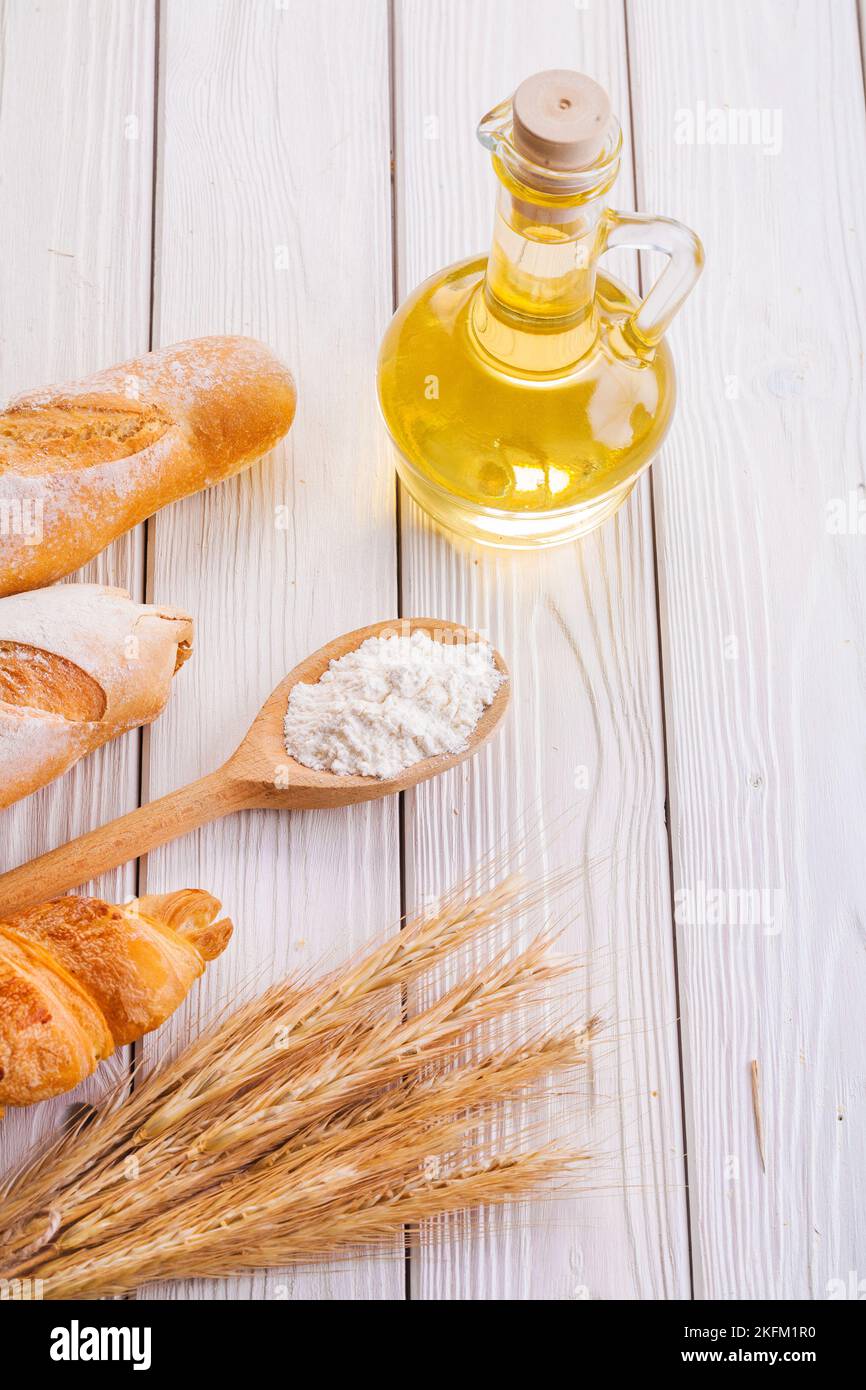 composition ears of rye croissant baguettes flour in spoon bottle oil ...