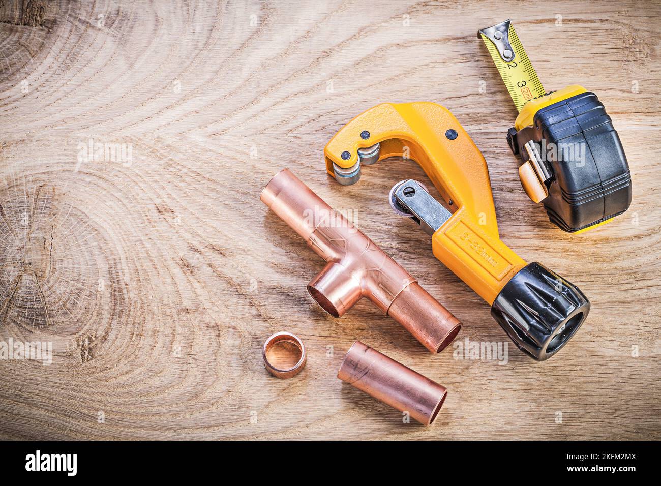 Copper water pipe cutter fittings tape measure on wood board top view ...