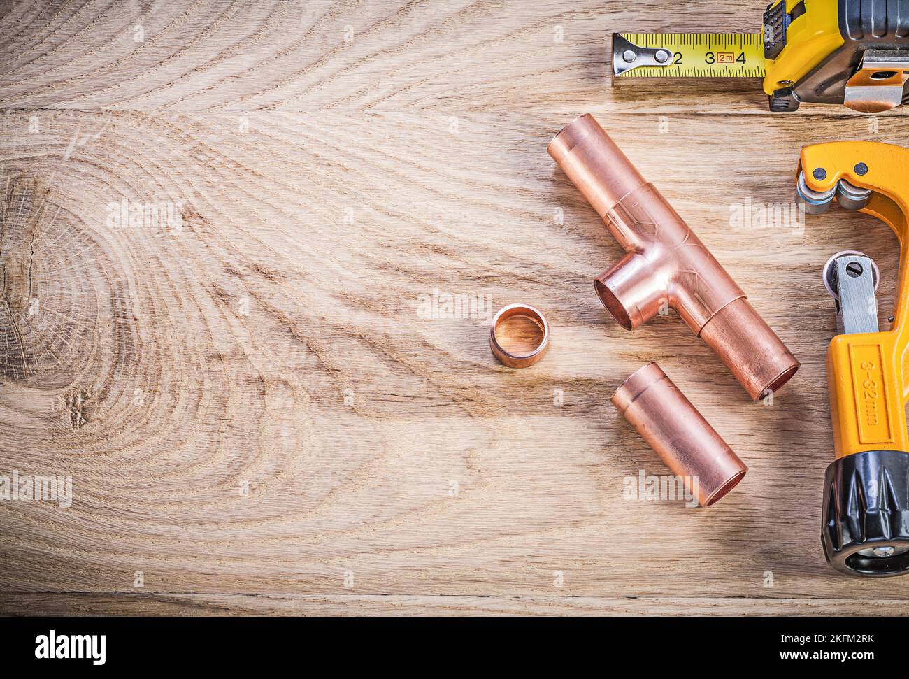 Copper water pipe cutter connectors tape line on wood board copy space ...