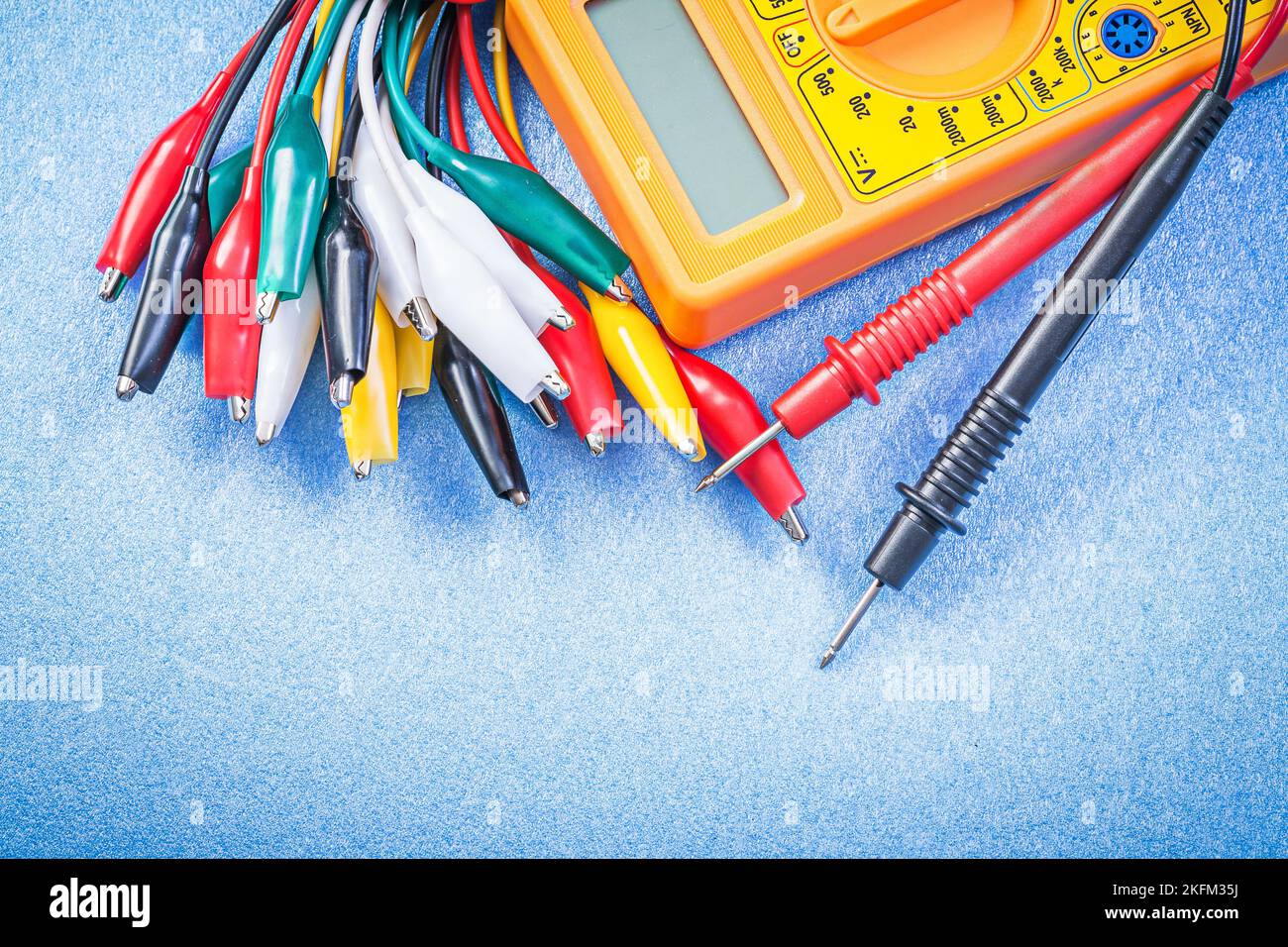 Crocodile plugs digital multimeter on blue background top view ...