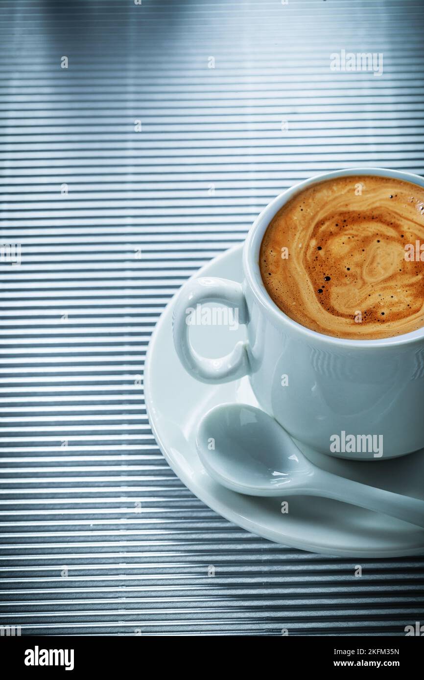 Cup of cappuchino coffee saucer teaspoon on striped background top view ...
