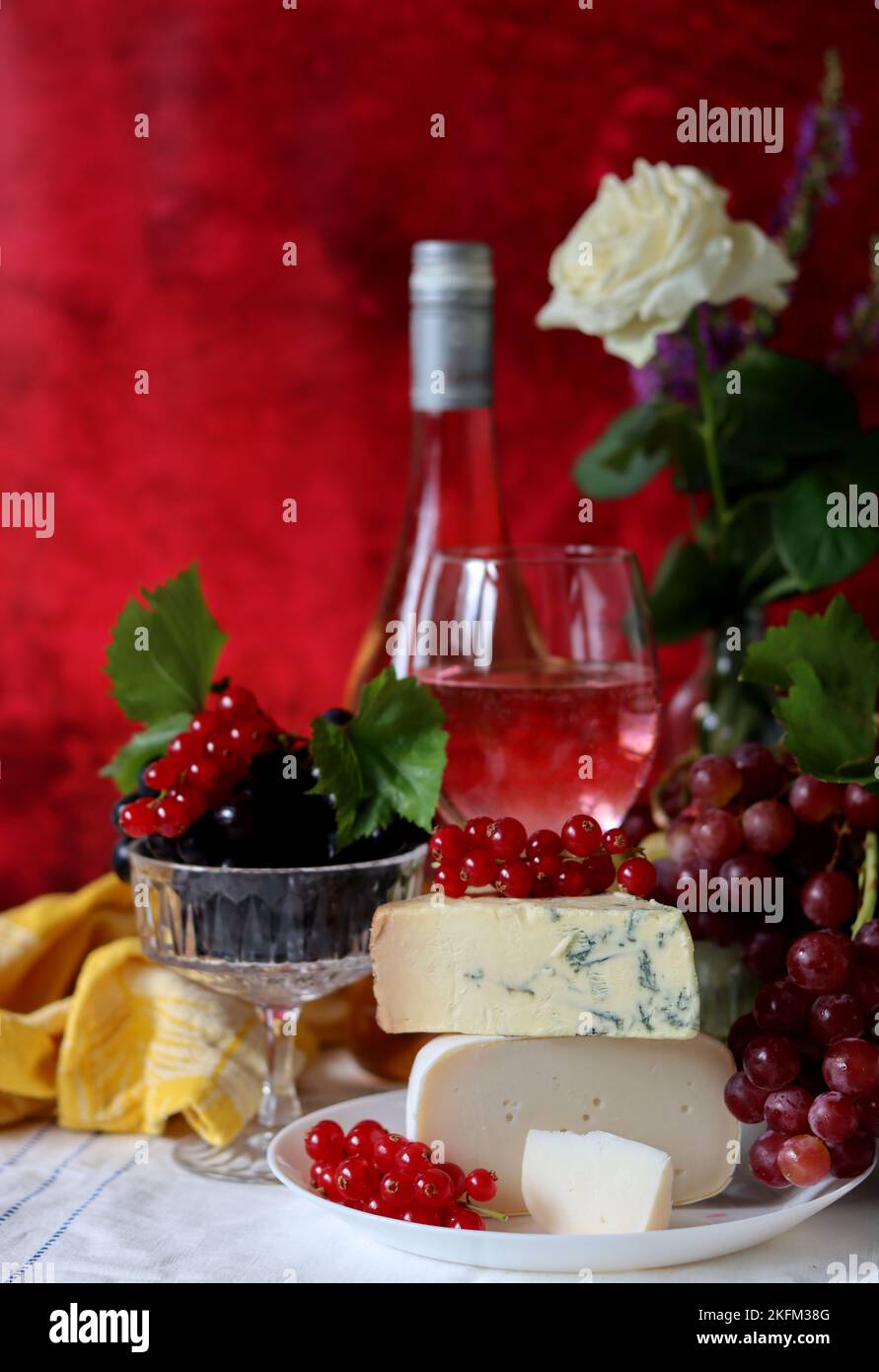 Wine, cheese, fruit and flowers on a table. Vibrant colors of fresh ...