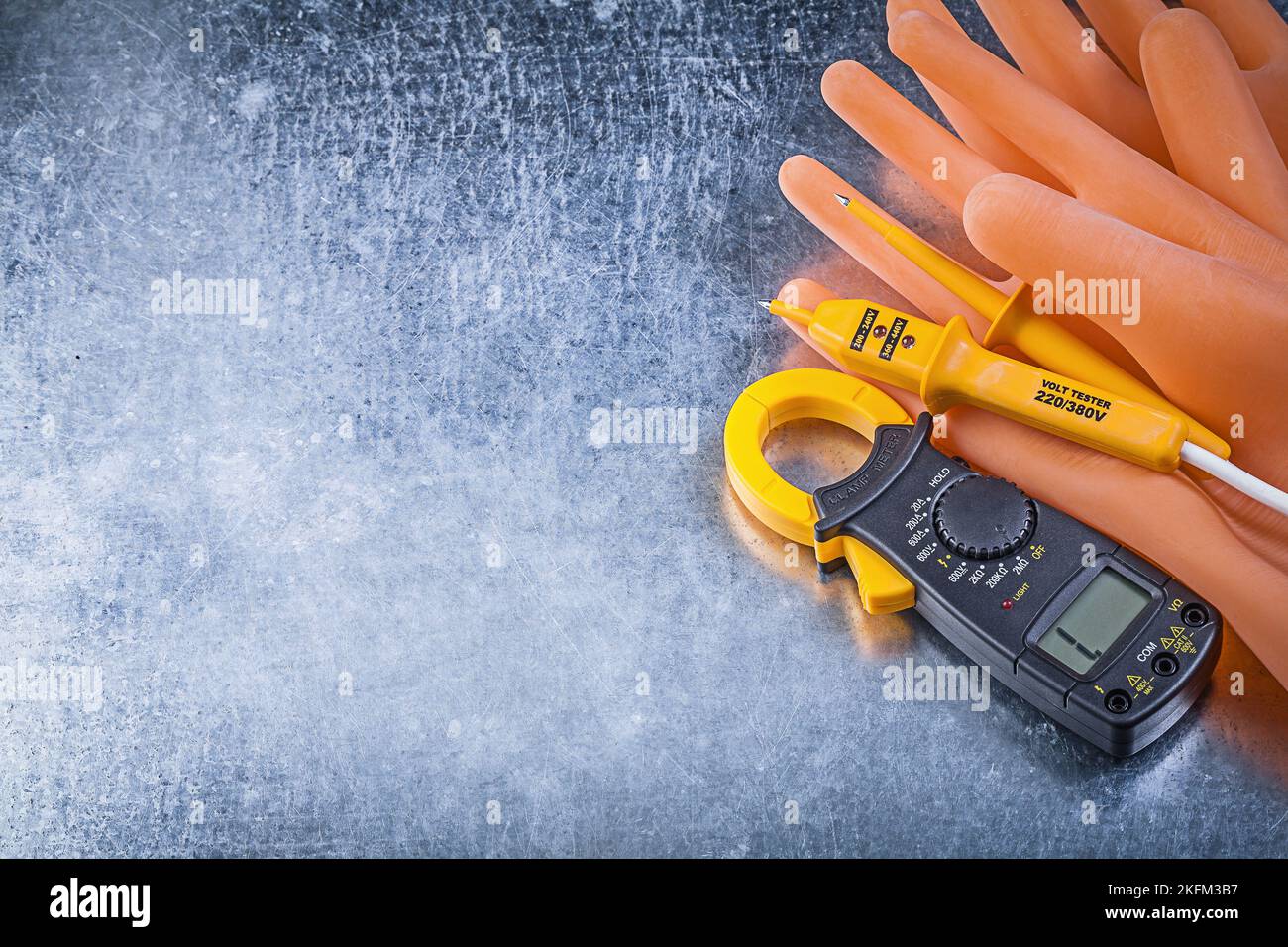 Digital clamp meter electrical tester insulating gloves on metallic ...