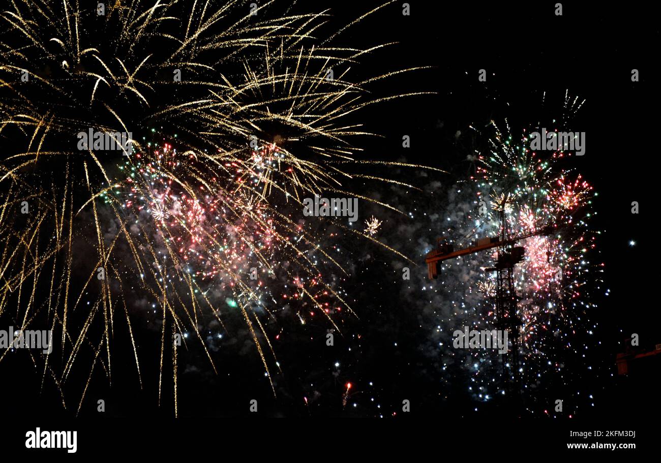 colorful fireworks at night with shadows of a construction site and ...