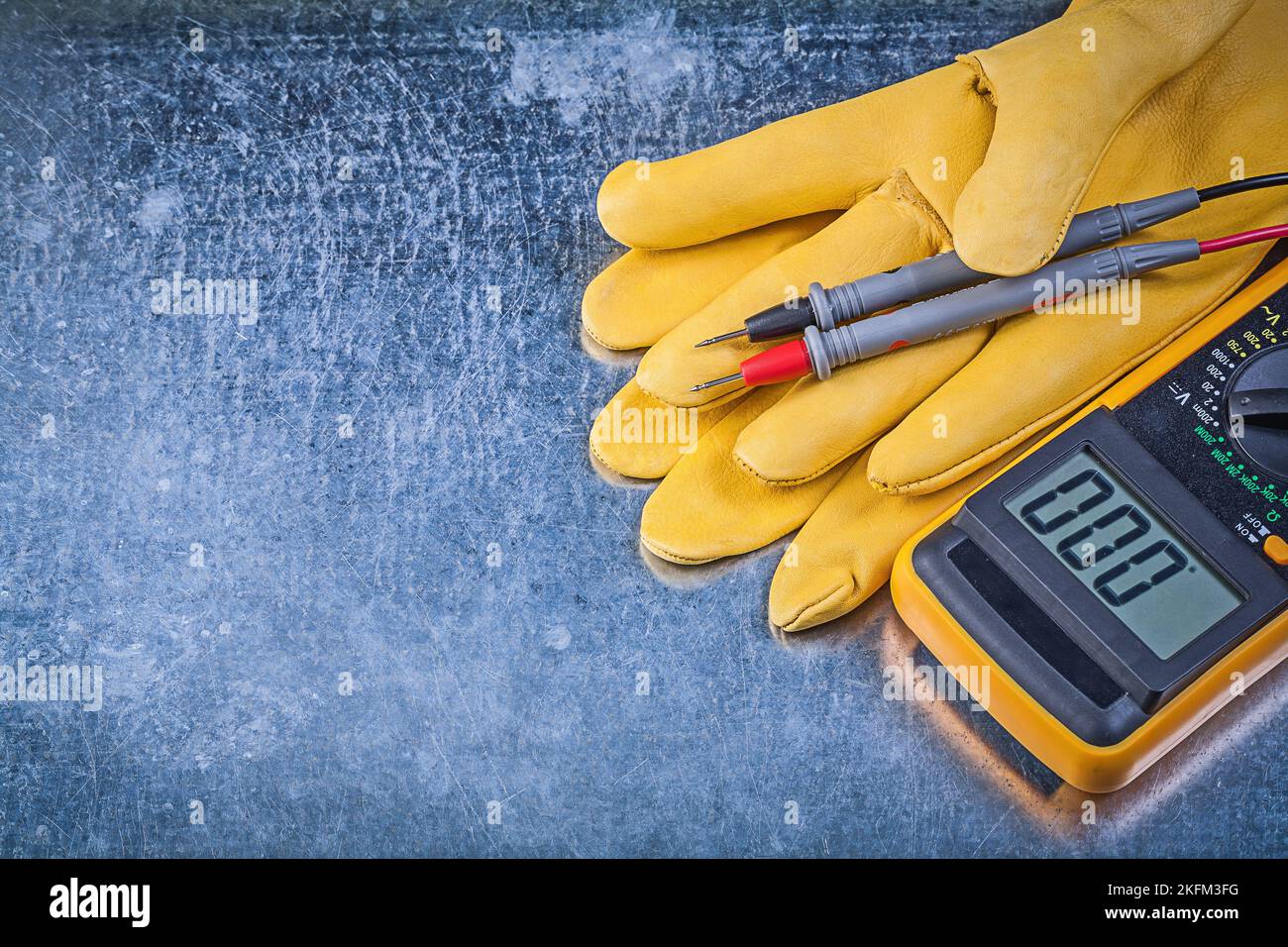 Digital electric tester protective gloves on metallic background ...