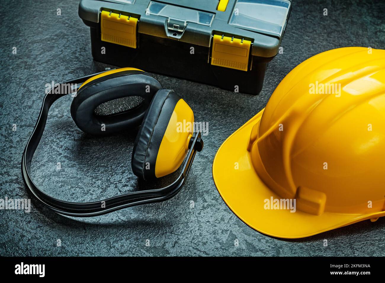 earphones helmet and tool box on black background Stock Photo - Alamy