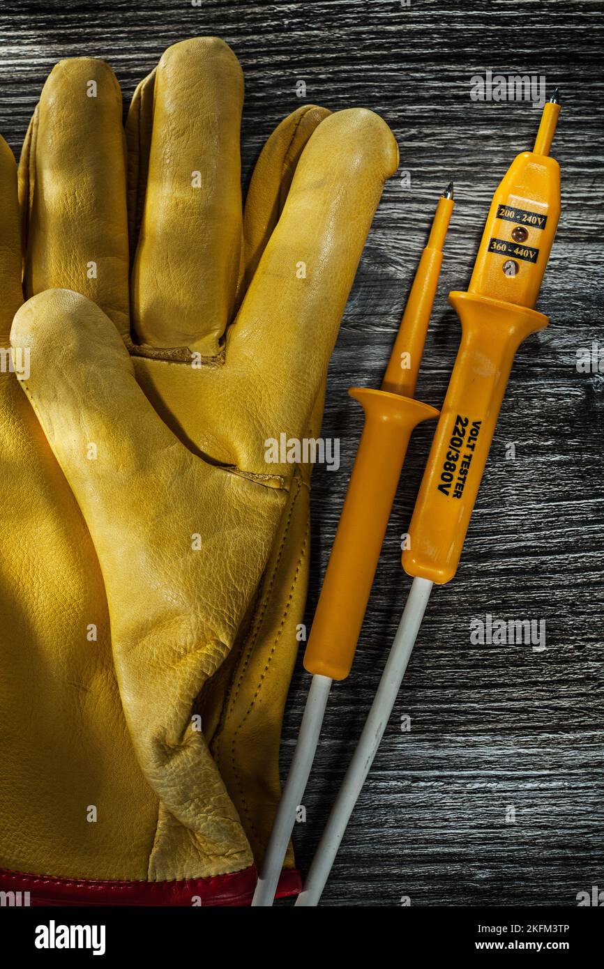 Electric tester leather safety gloves on wooden board Stock Photo - Alamy