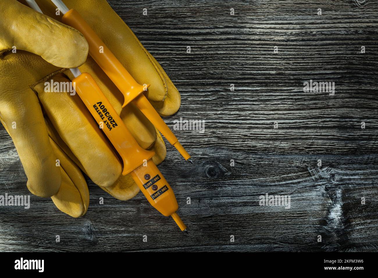 Electric tester leather protective gloves on vintage wooden board Stock ...