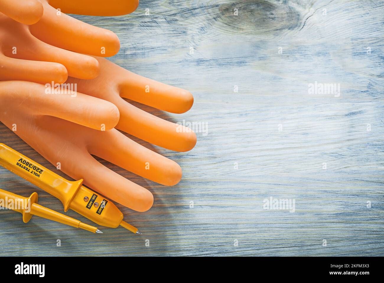 Electric tester pair of electricians gloves on wooden board electricity ...